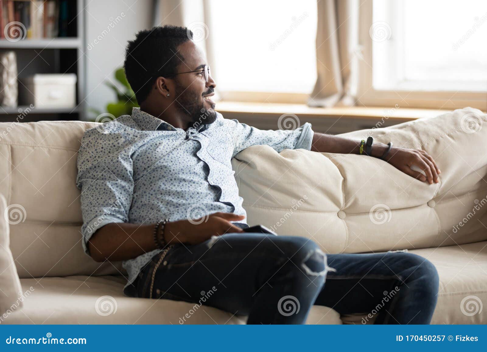 Relaxed African Guy Chill on Sofa at Home Holding Phone Stock Image ... Relaxed African Guy Chill on Sofa at Home Holding Phone Stock Image ...