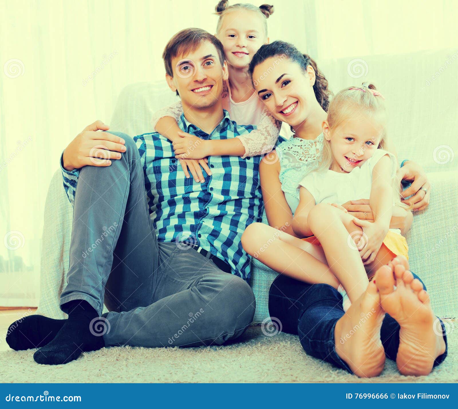 Relaxed Family of Four Posing Stock Photo - Image of middle, furnished ...