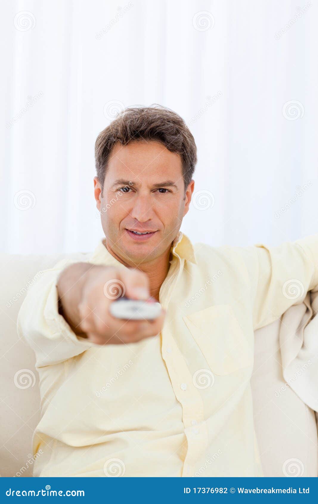Relaxed Man Pointing a Remote To the Camera Stock Photo - Image of ...