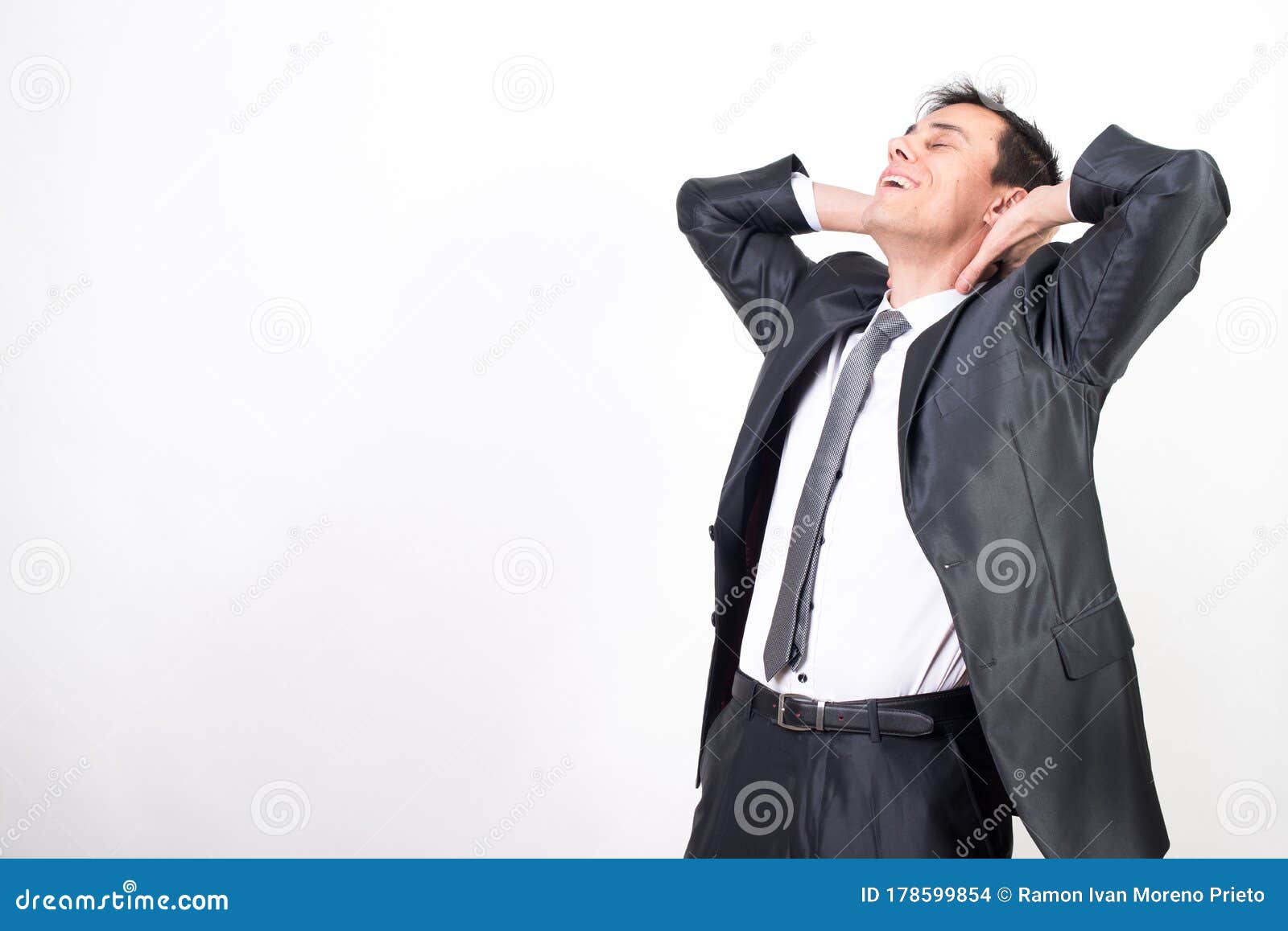 Relaxed Man in Suit Leaning Back with His Hands on the Back of His Neck ...