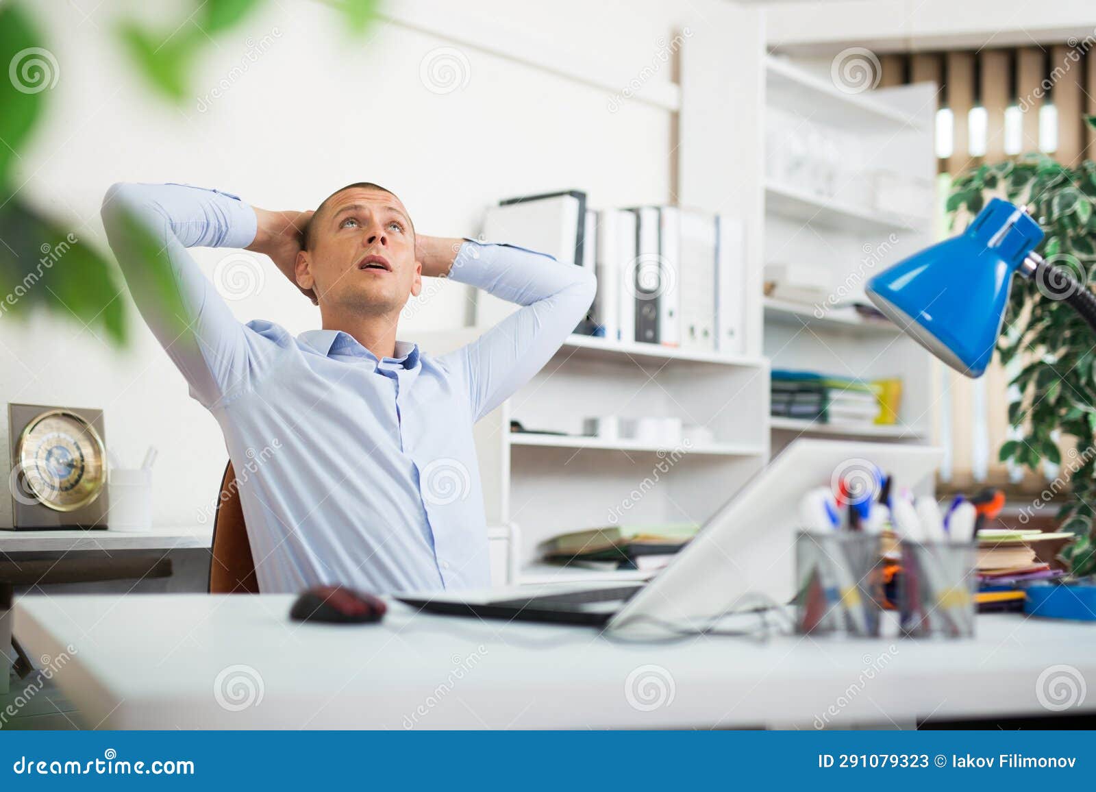 Relaxed Office Worker Sitting at Workplace with Hands Behind Head Stock ...
