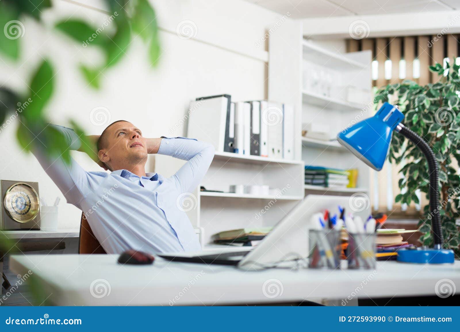 Relaxed Office Worker Sitting at Workplace with Hands Behind Head Stock ...