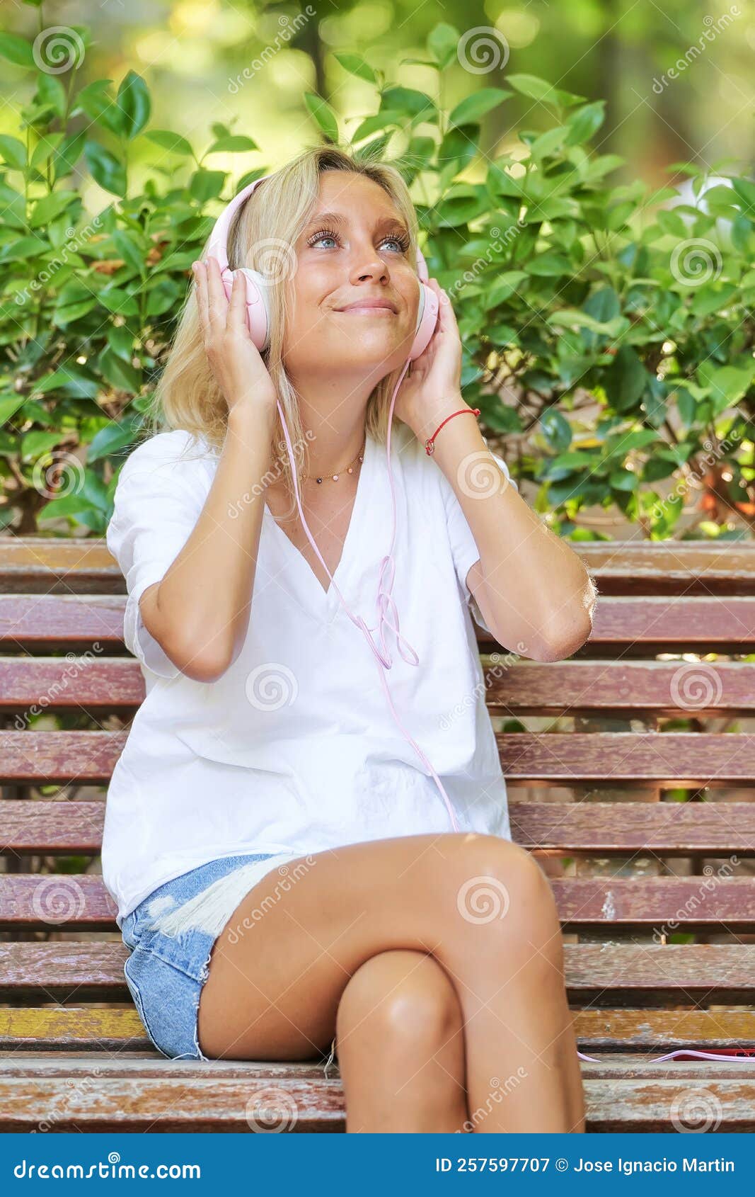 Relaxed Woman Looking Away And Smiles While Listening Music With