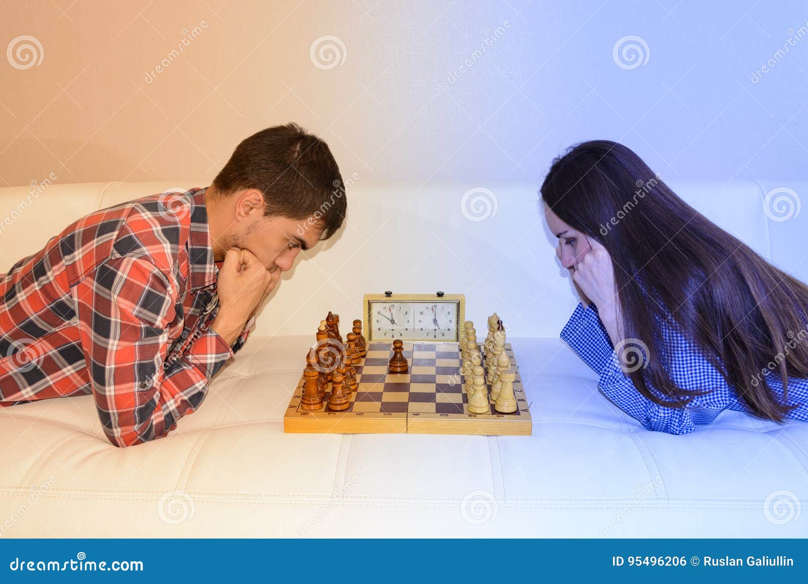 Relaxed Young Couple Playing Chess at Home Lying on Sofa. Won ...