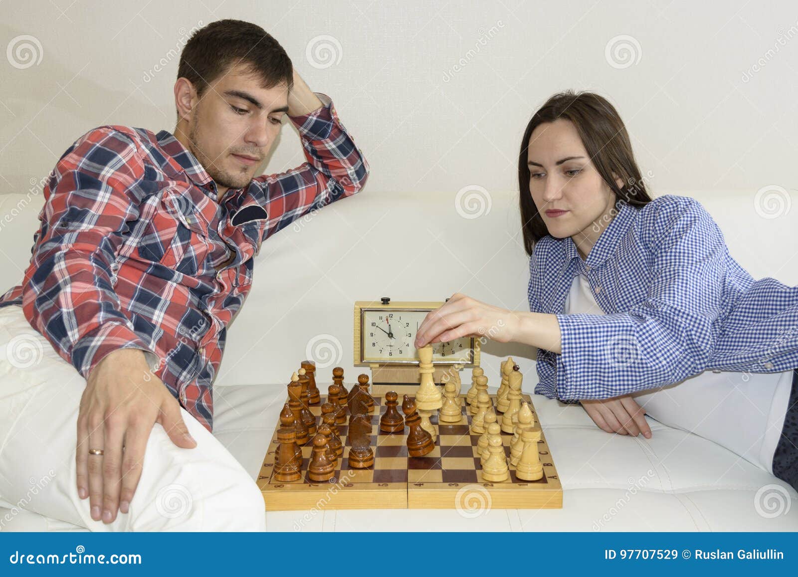 Relaxed Young Couple Playing Chess at Home Lying on Sofa. Won ...
