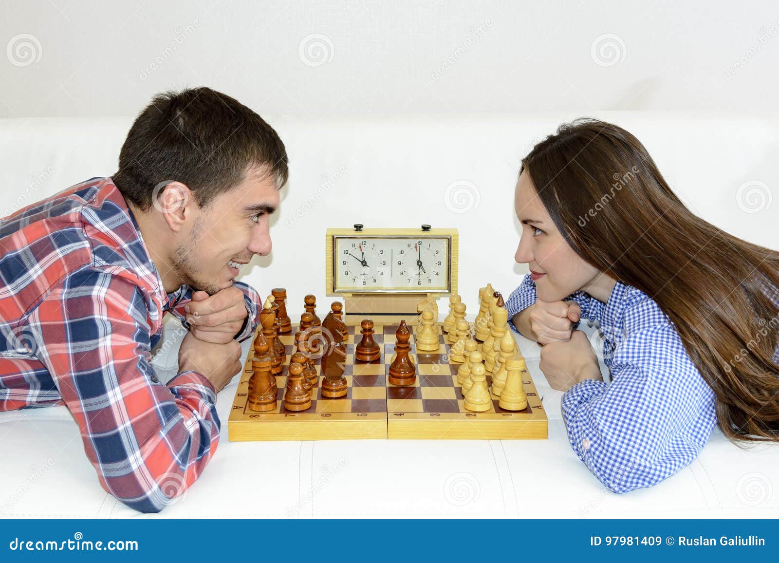 Relaxed Young Couple Playing Chess at Home Lying on Sofa. Stock Image ...