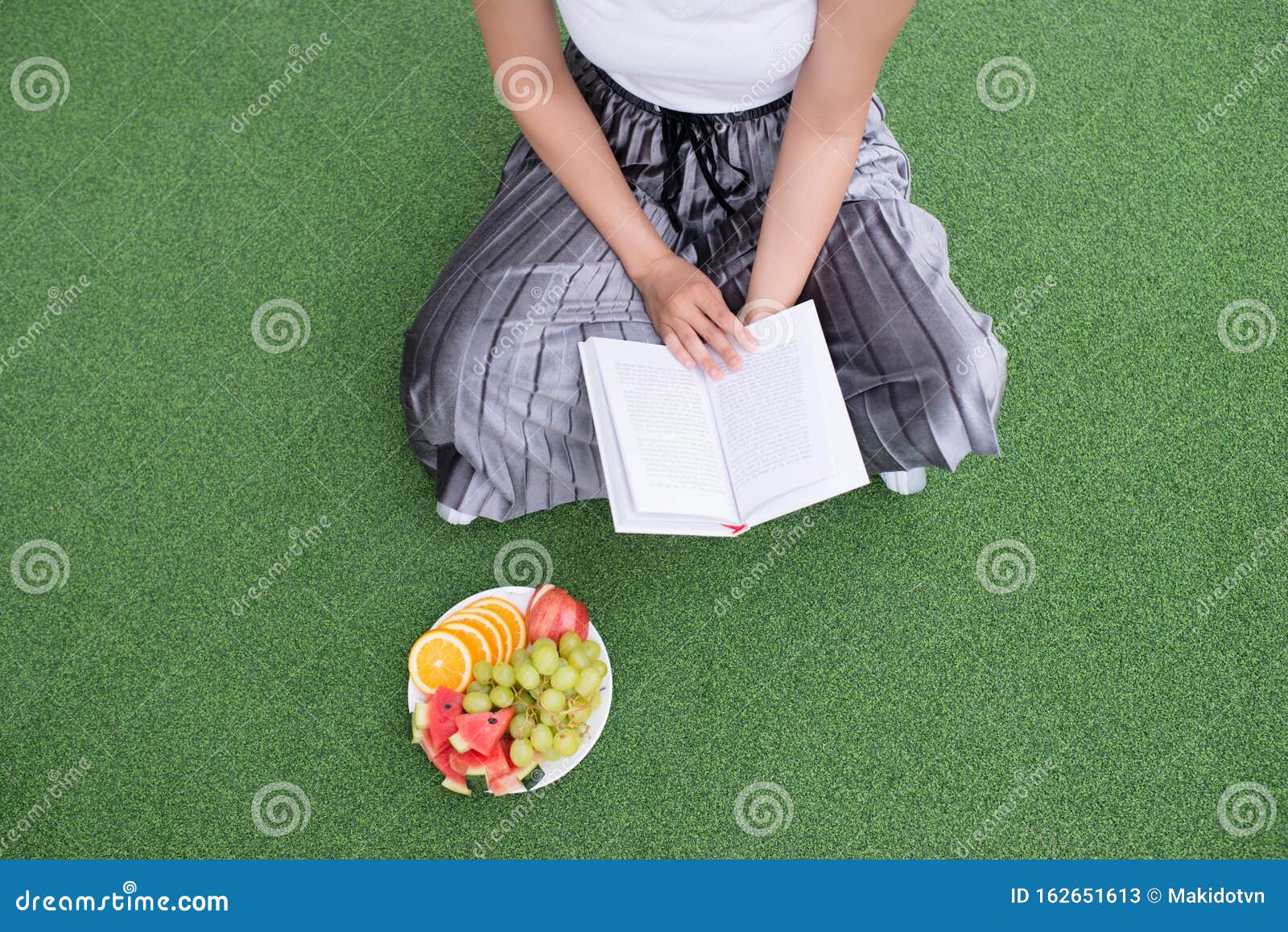 Relaxing Moments Young Woman Reading A Book While Sitting On The Grass