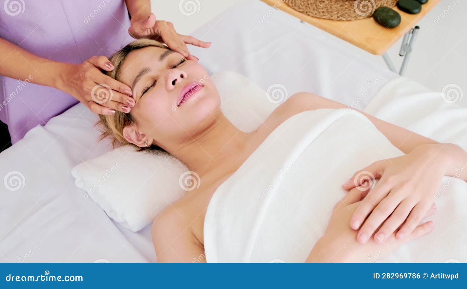 Relaxing Young Asian Woman Lying Down And Closing Her Eyes On Massage