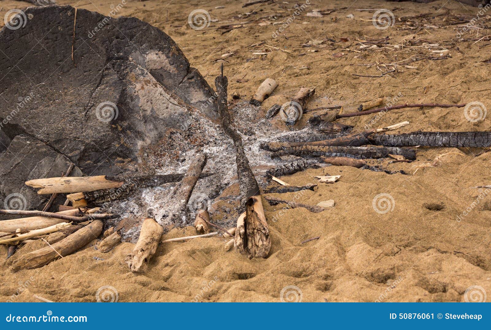 The Remains Of A Campfire Made With Three Thick Logs And A Metal Pod In ...