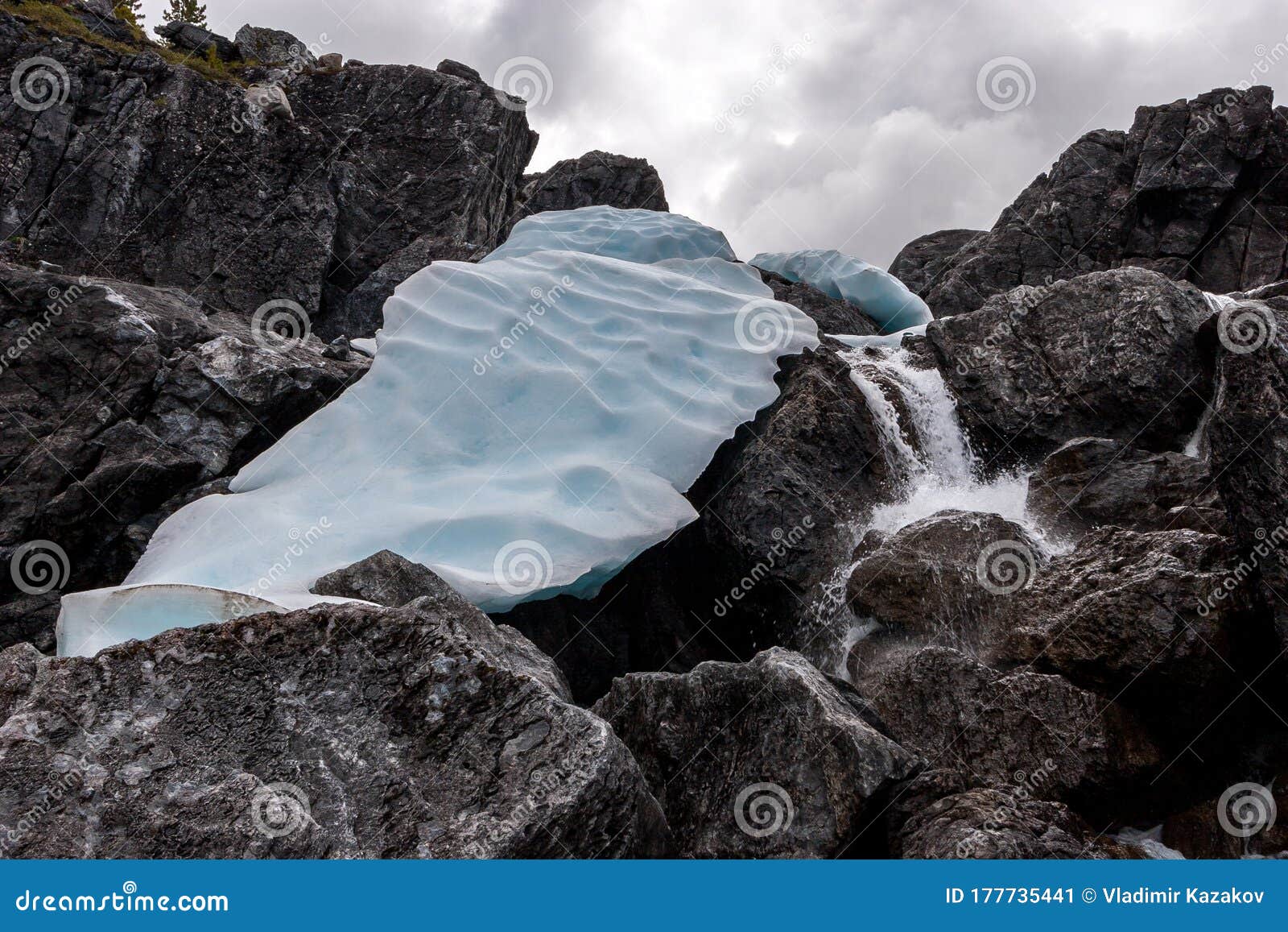 Remains of Old Ice on Stones through Which Water Flows. Stock Image ...