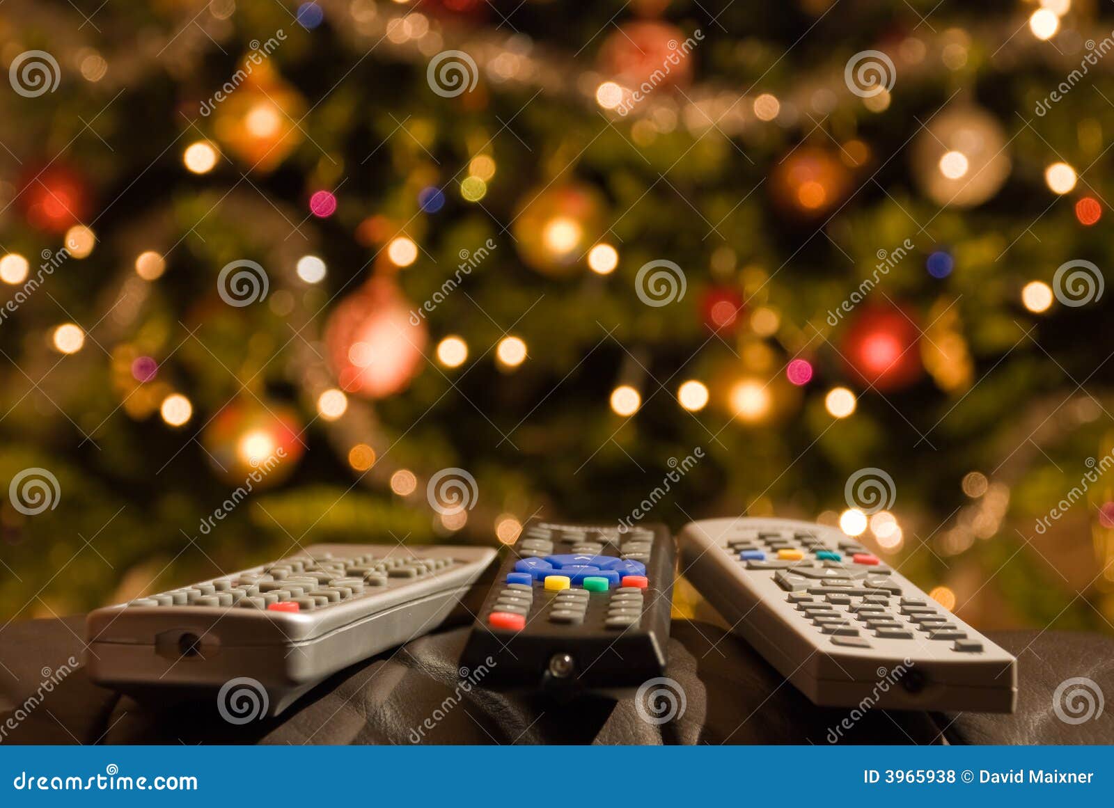 Remote Controls in Front of Lit Christmas Tree Stock Photo - Image of ...