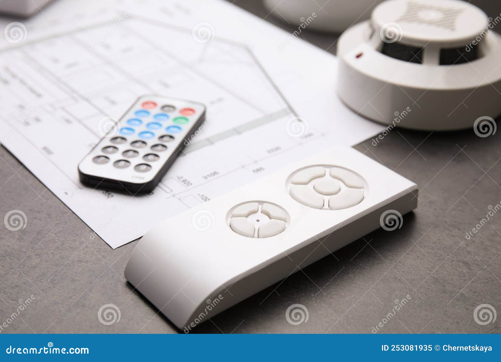 Remote Controls, Smoke Detector and Building Plan on Grey Table. Home ...