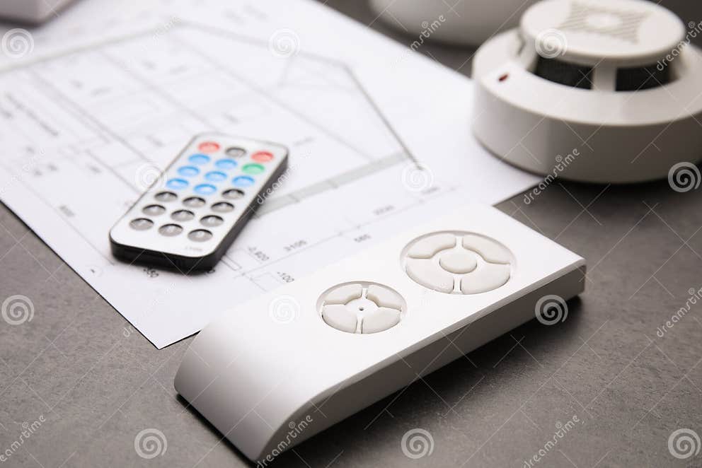 Remote Controls, Smoke Detector and Building Plan on Grey Table. Home ...
