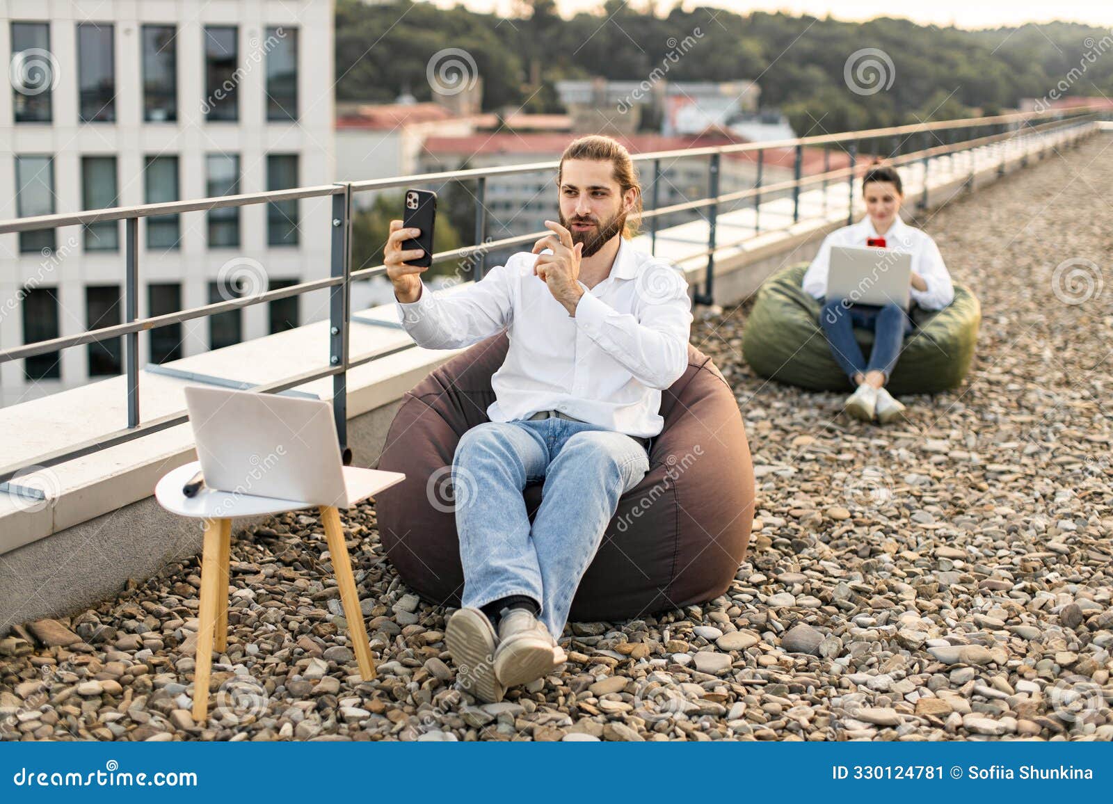 Remote Workers on Rooftop Working with Laptops and Smartphones Stock ...