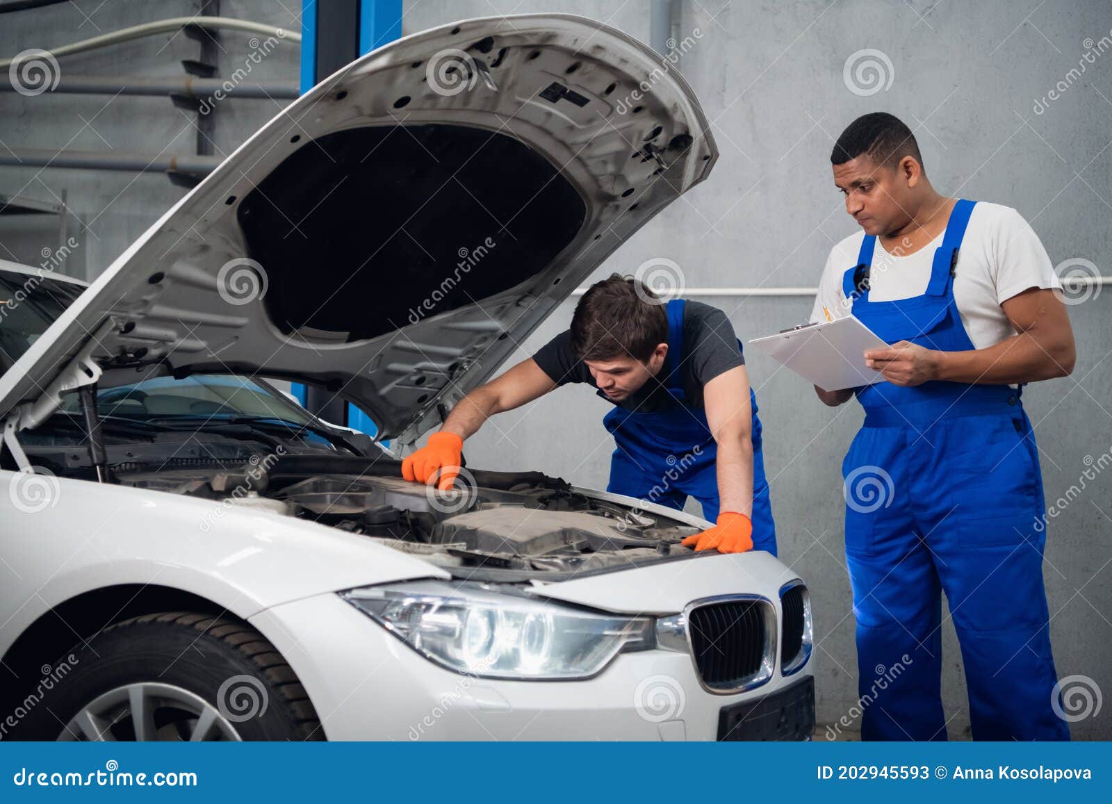 Men Repair a Car Engine and Writes on Clipboard Stock Image - Image of ...