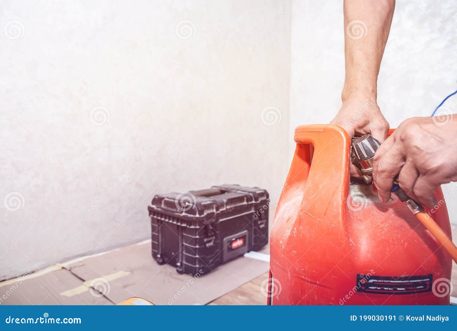 Repairers Stretch the Stretch Ceiling with a Gas Heat Gun. Worker ...