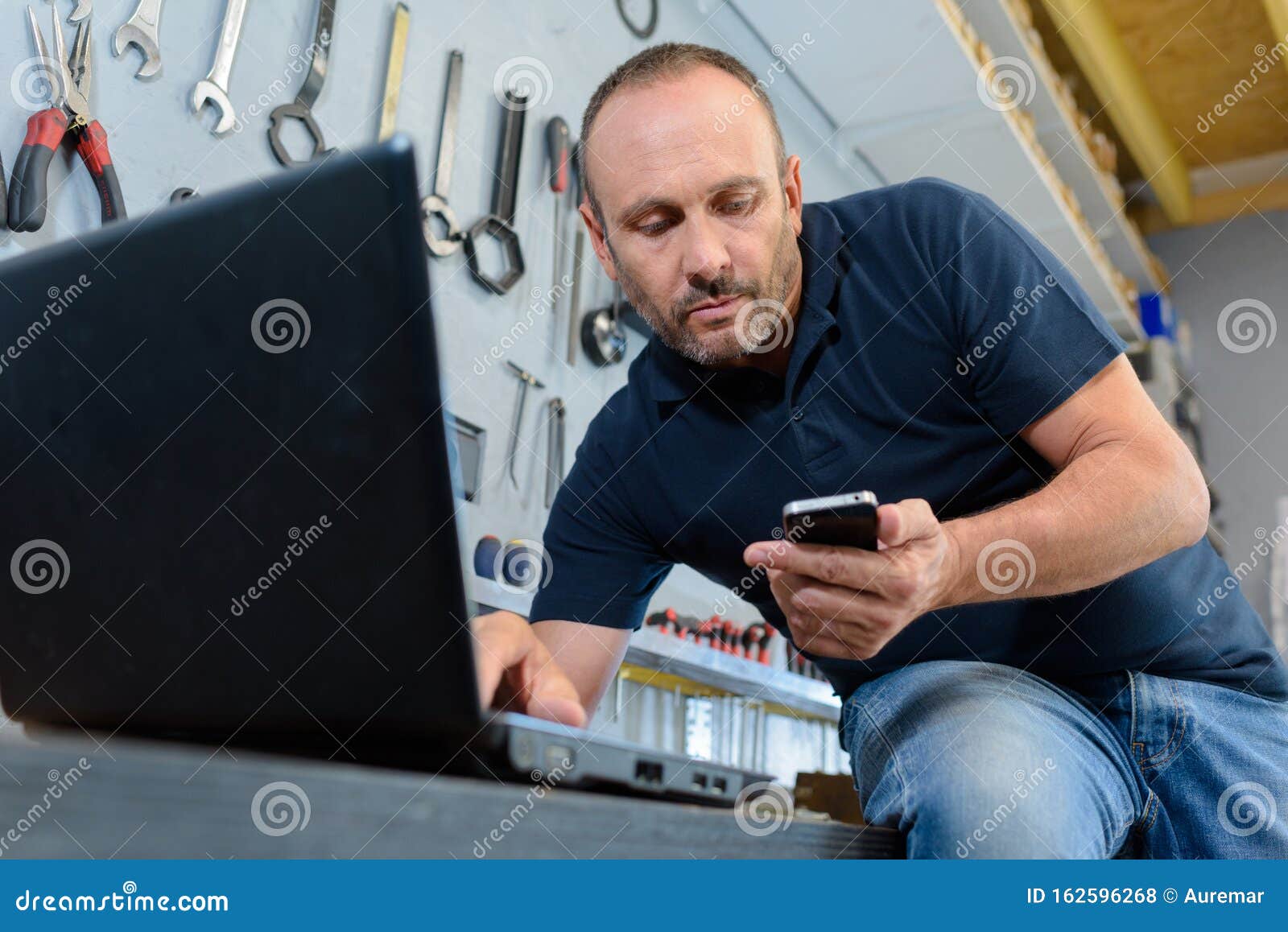 Repairman Checking Phone in Workshop Stock Photo - Image of plank ...