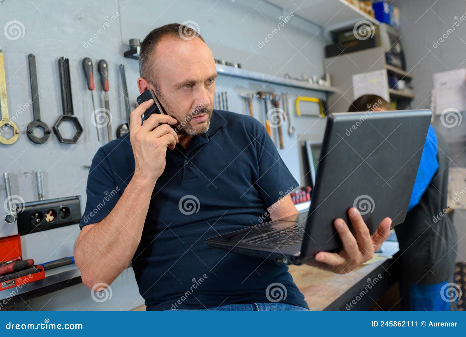 Repairman on Phone while Looking at Laptop Stock Image - Image of ...