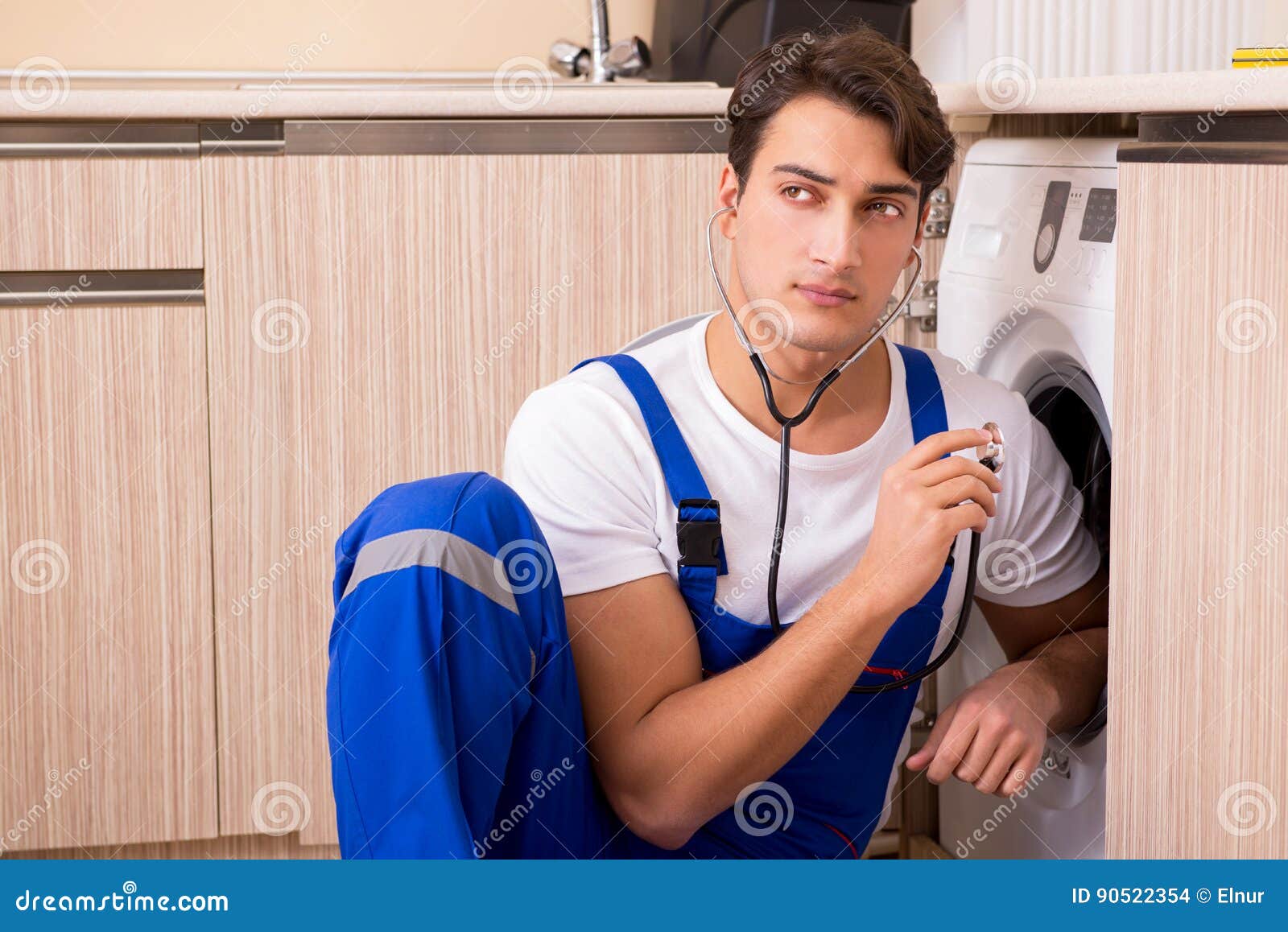 The Repairman Repairing Washing Machine at Kitchen Stock Photo - Image ...