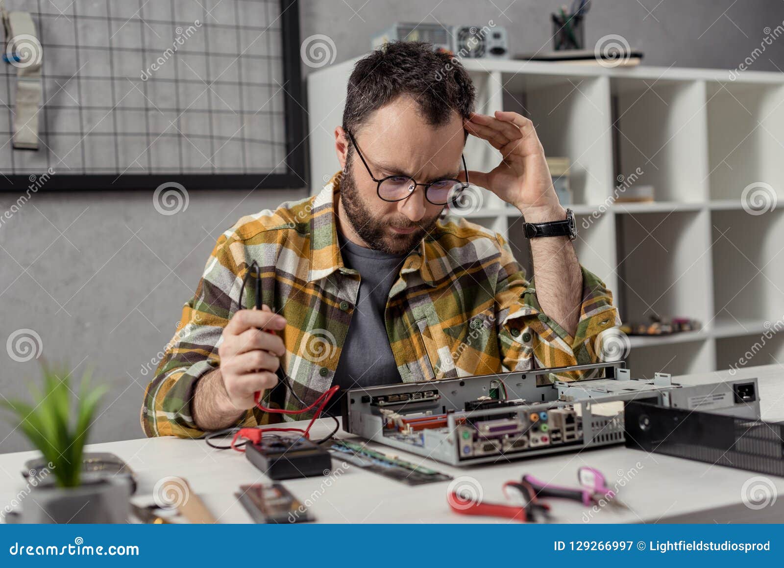 Repairman Using Multimeter while Fixing Broken Computer and Looking ...