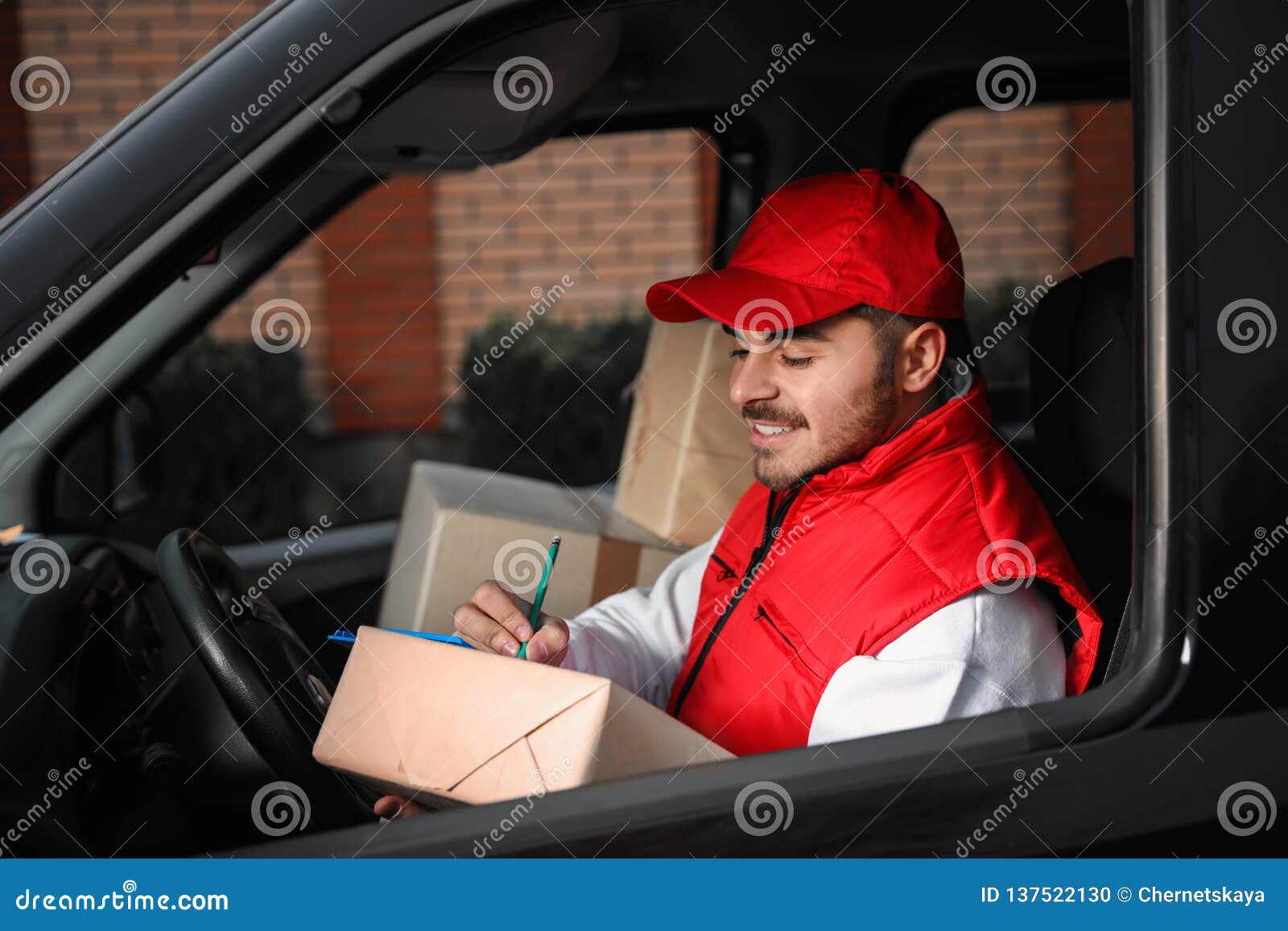 Repartidor En Uniforme Con Los Paquetes Foto de archivo - Imagen de ...