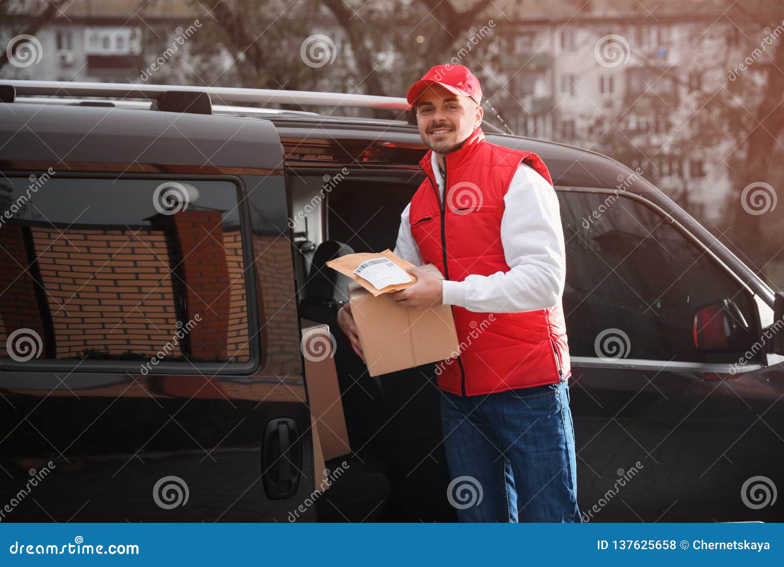 Repartidor En Uniforme Con Los Paquetes Foto de archivo - Imagen de ...