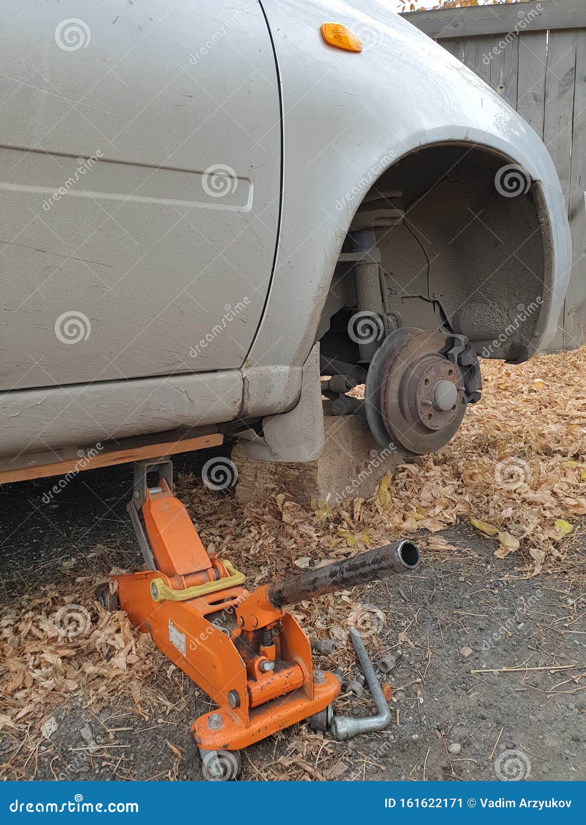 Car Lifted On Jack. Mechanic Lifting Up The Car With Car Jack. Tire ...