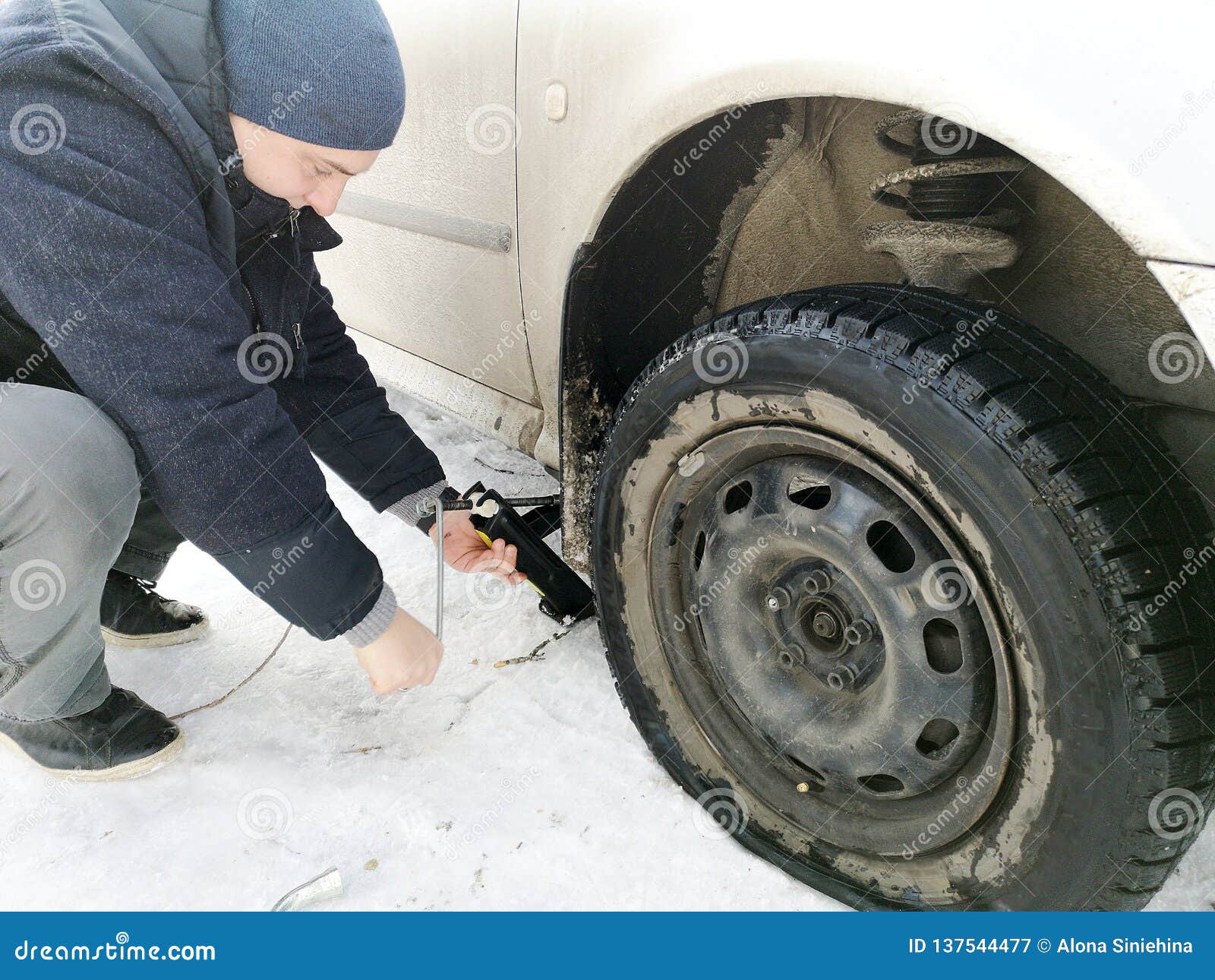 Punched and Flat Tire on the Road. Replacing the Wheel with a Jack by ...