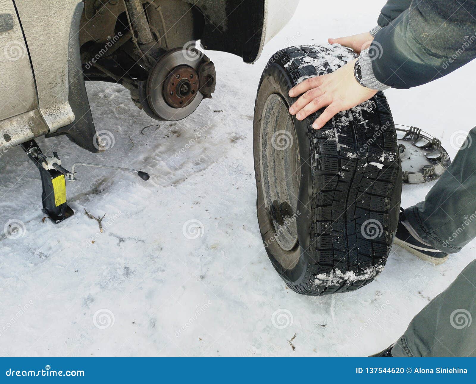 Punched and Flat Tire on the Road. Replacing the Wheel with a Jack by ...