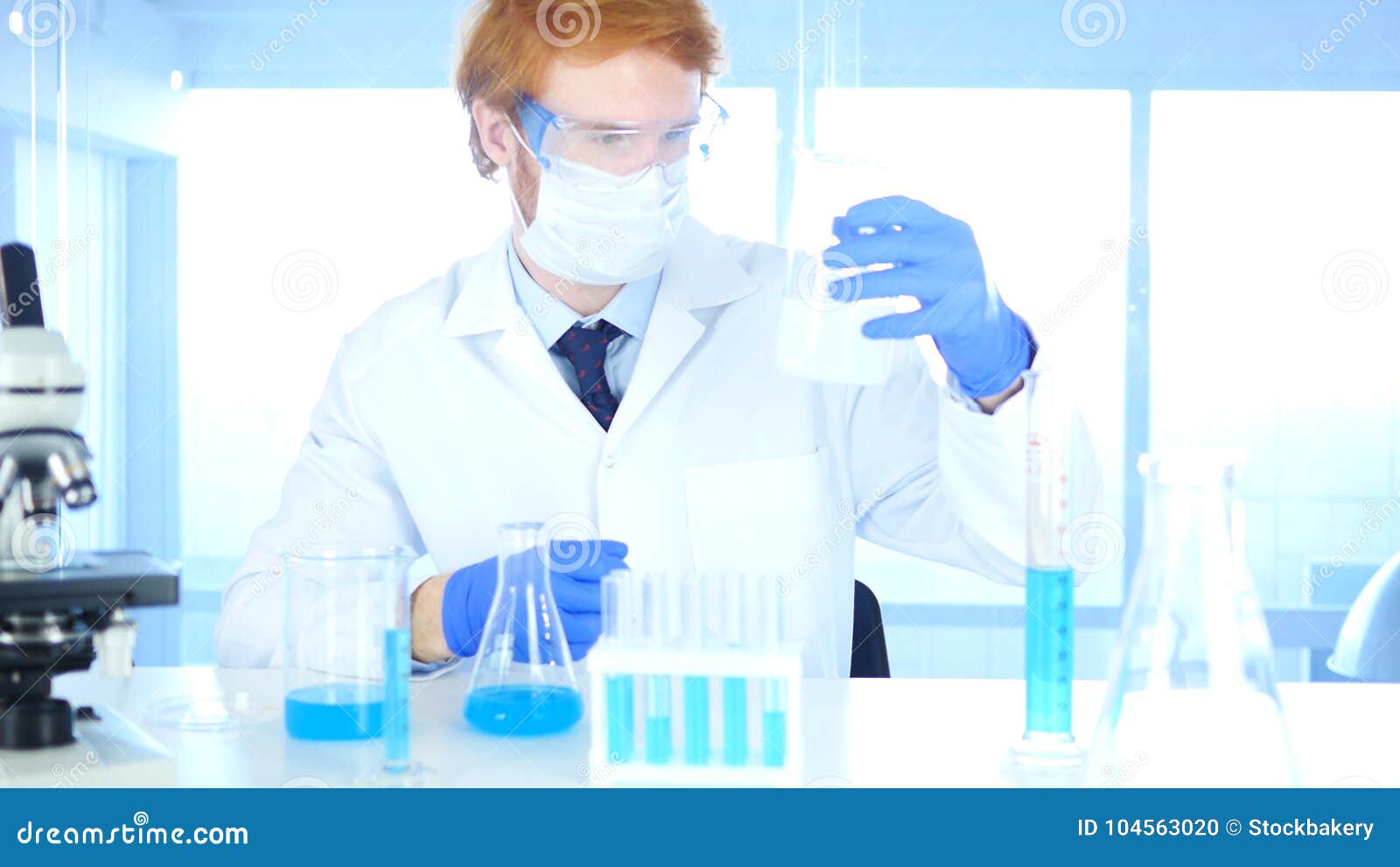 Research Scientist Looking at Solution in Beaker in Laboratory ...