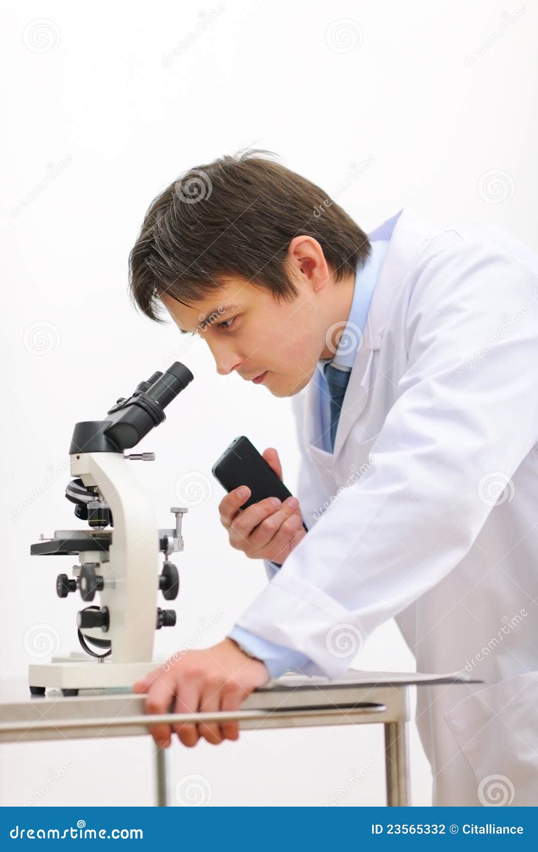 Researcher Looking in Microscope and Making Notes Stock Photo - Image ...
