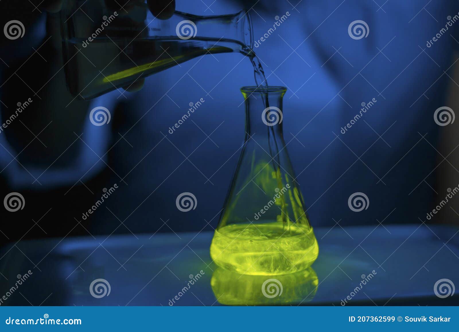 A Researcher Working with a Green Fluorescent Solution in a Glass ...