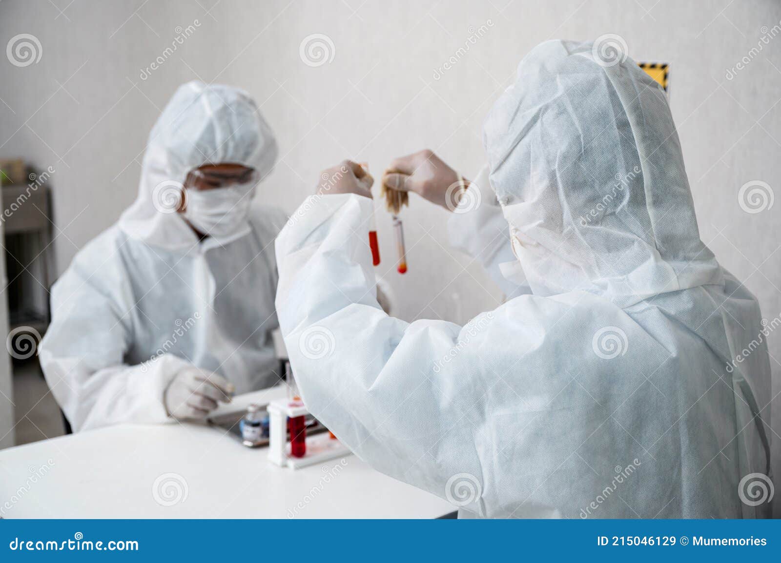 Researchers and Assistant in PPE Analyzing a Sample Blood in Test Tube ...