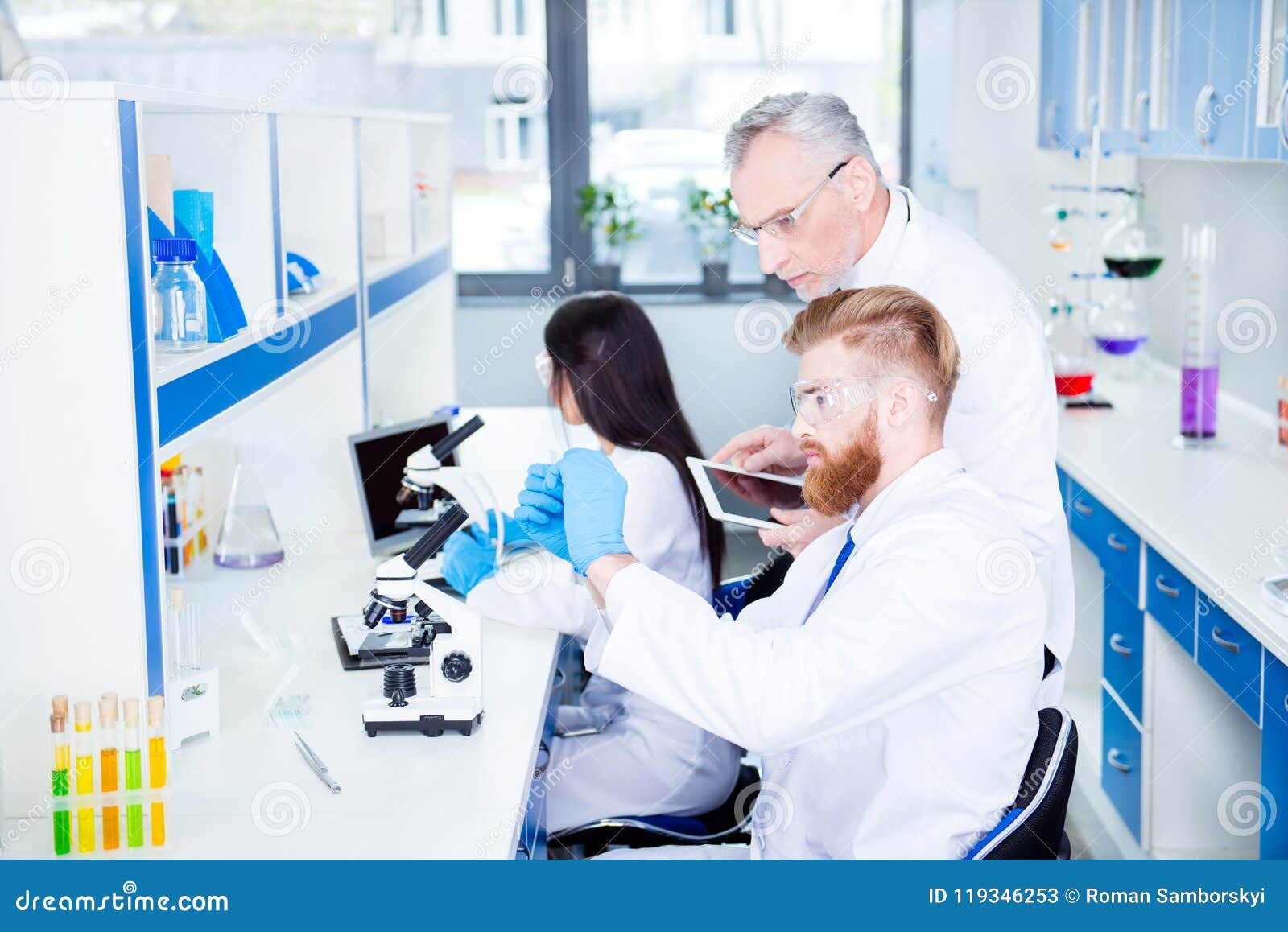 Researchers in Labcoats are Checking the Samples on Microscope I Stock ...
