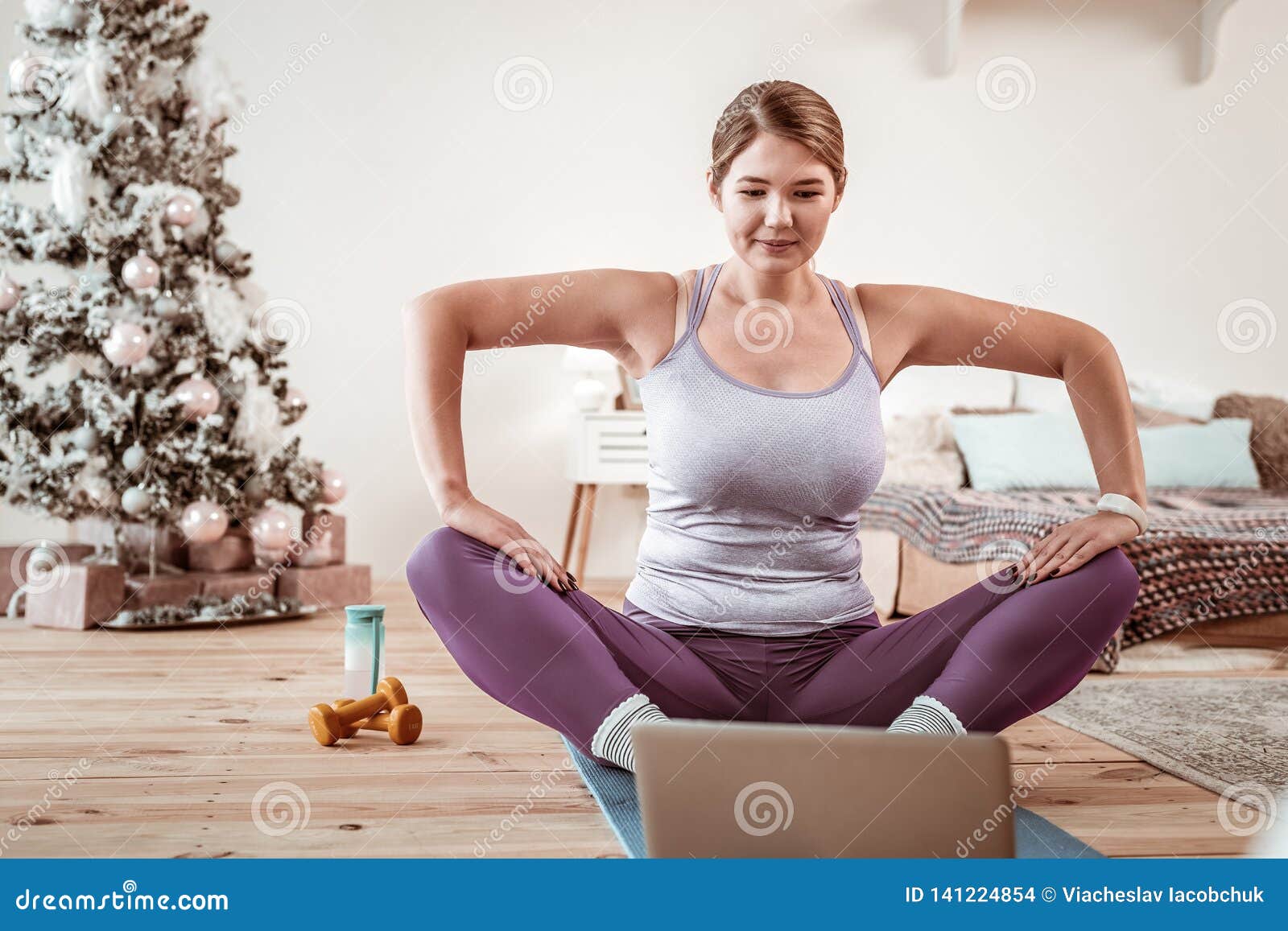 Resolute Appealing Woman Recreating Yoga Posture from Video Lesson ... Resolute Appealing Woman Recreating Yoga Posture from Video Lesson ...