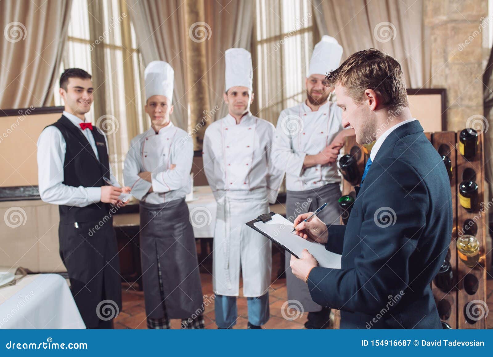 Restaurant Manager and His Staff in Kitchen. Interacting To Head Chef ...