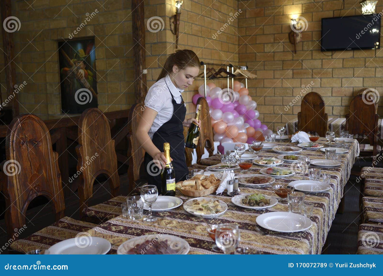 At a Restaurant: Waitress in Uniform Setting the Table Editorial Stock ...
