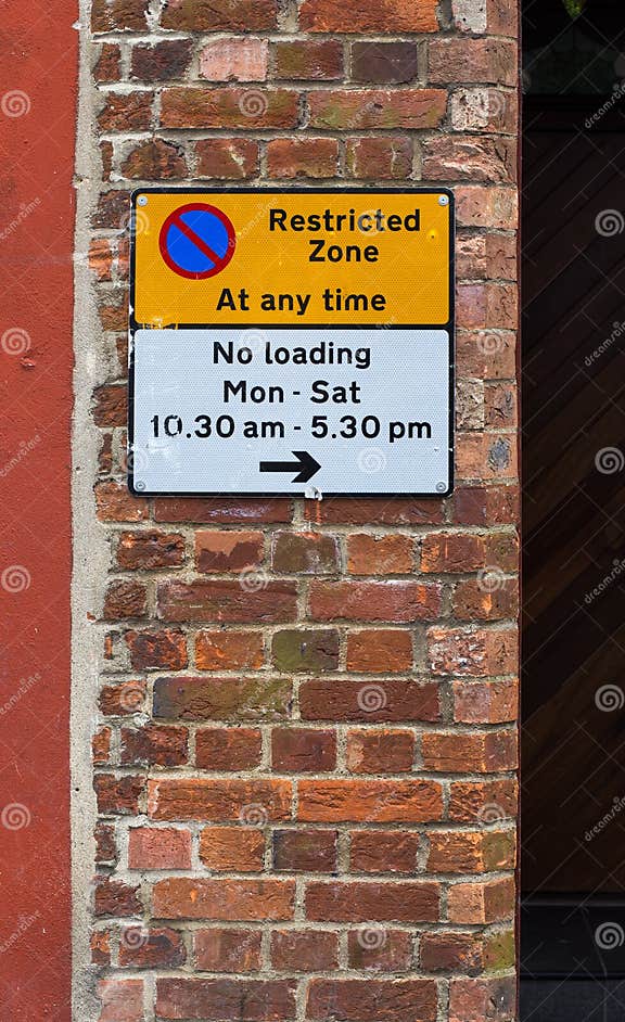 Restricted Zone Sign on the Red Brick Wall and No Loading Times Stock ...