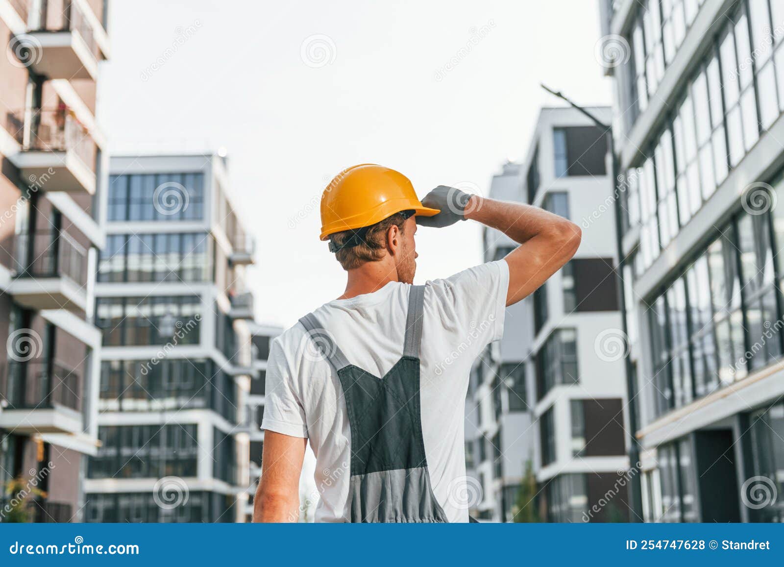 Results of Work. Young Man in Uniform at Construction at Daytime Stock ...