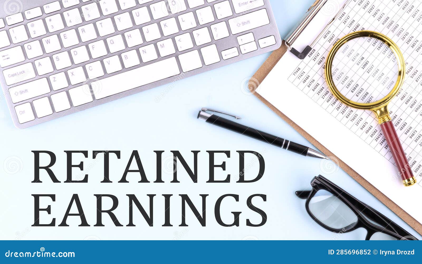 RETAINED EARNINGS Text on Blue Background with Keyboard and Clipboard ...