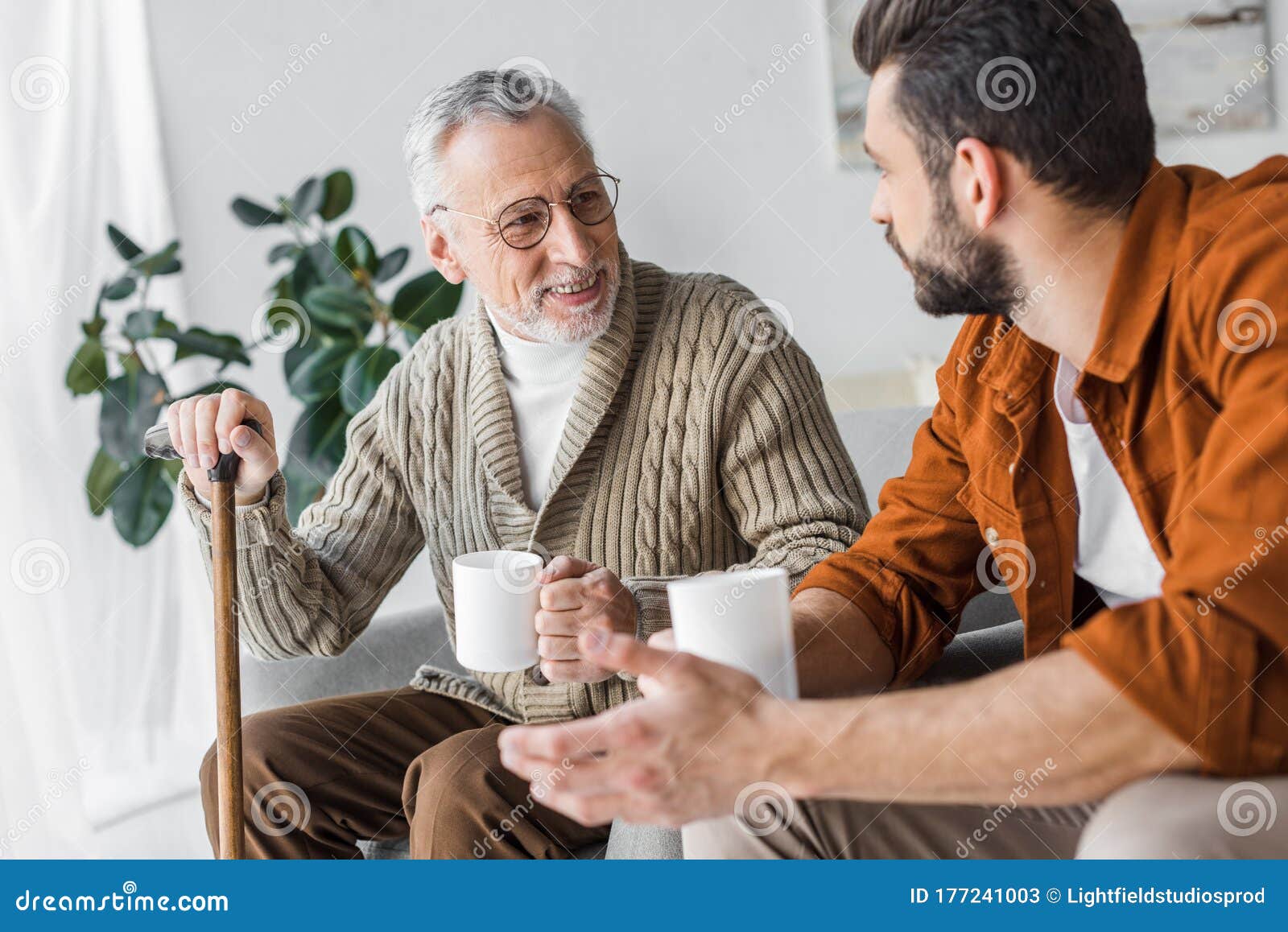 Retired Father in Glasses Looking at Handsome Son Holding Cup Stock ...