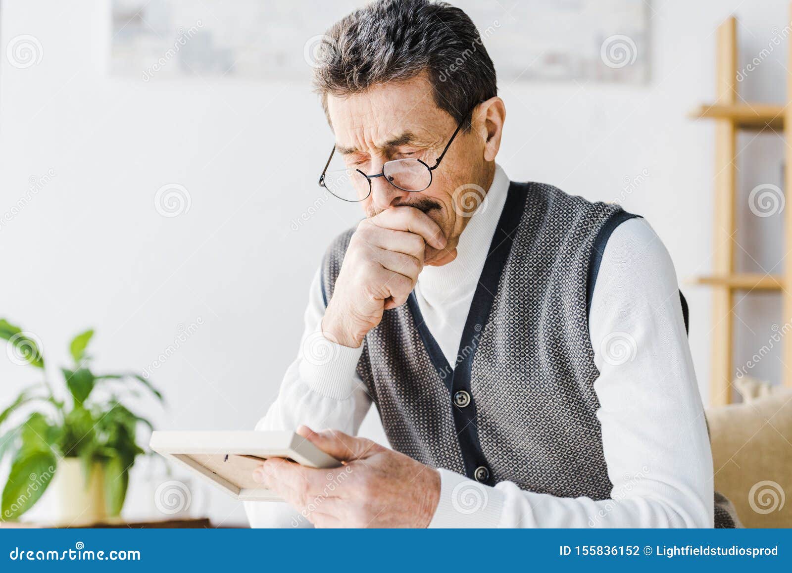 Retired Man in Glasses Crying while Looking at Photo Stock Photo ...