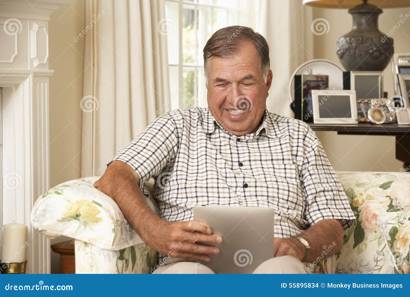 Retired Senior Man Sitting on Sofa at Home Using Tablet Computer Stock ...