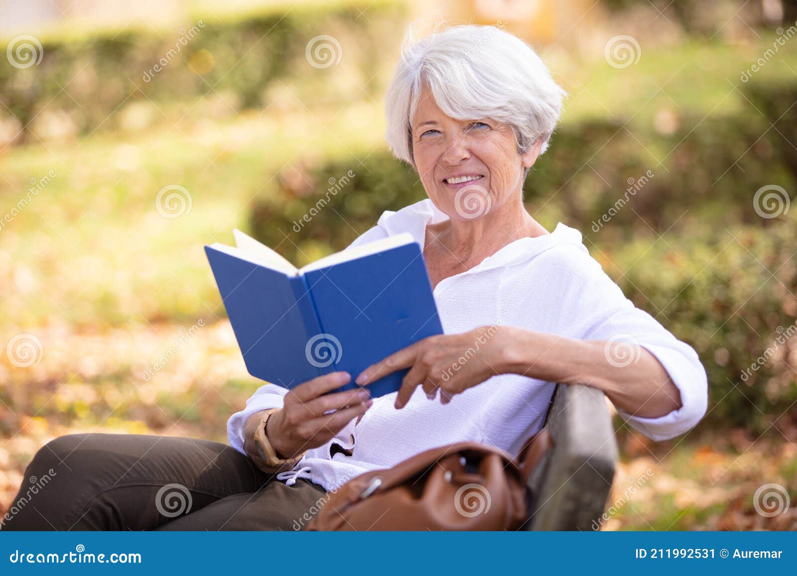 Retired Woman Reading Book on Park Bench Stock Image - Image of fifties ...