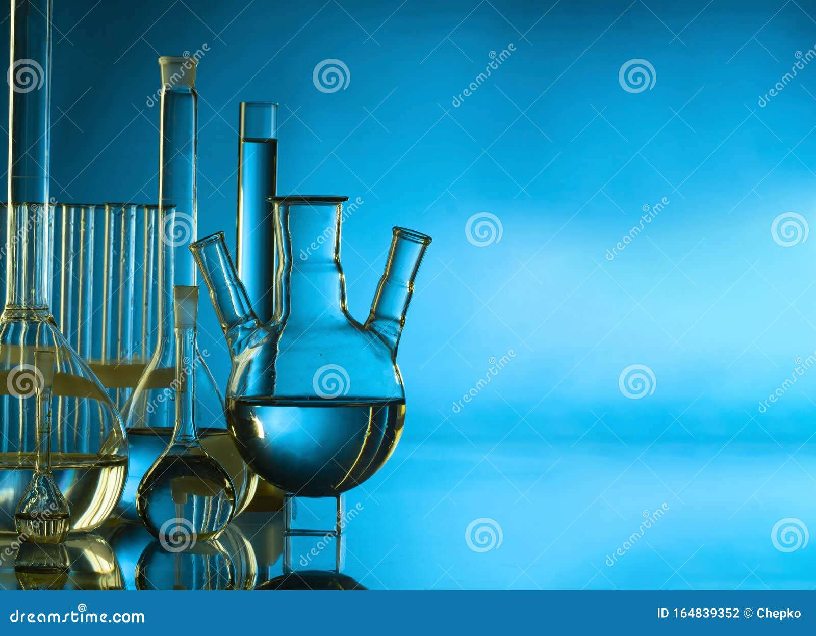 Retort Flask on Glass Table with Blue Liquid on Table Against Blue ...