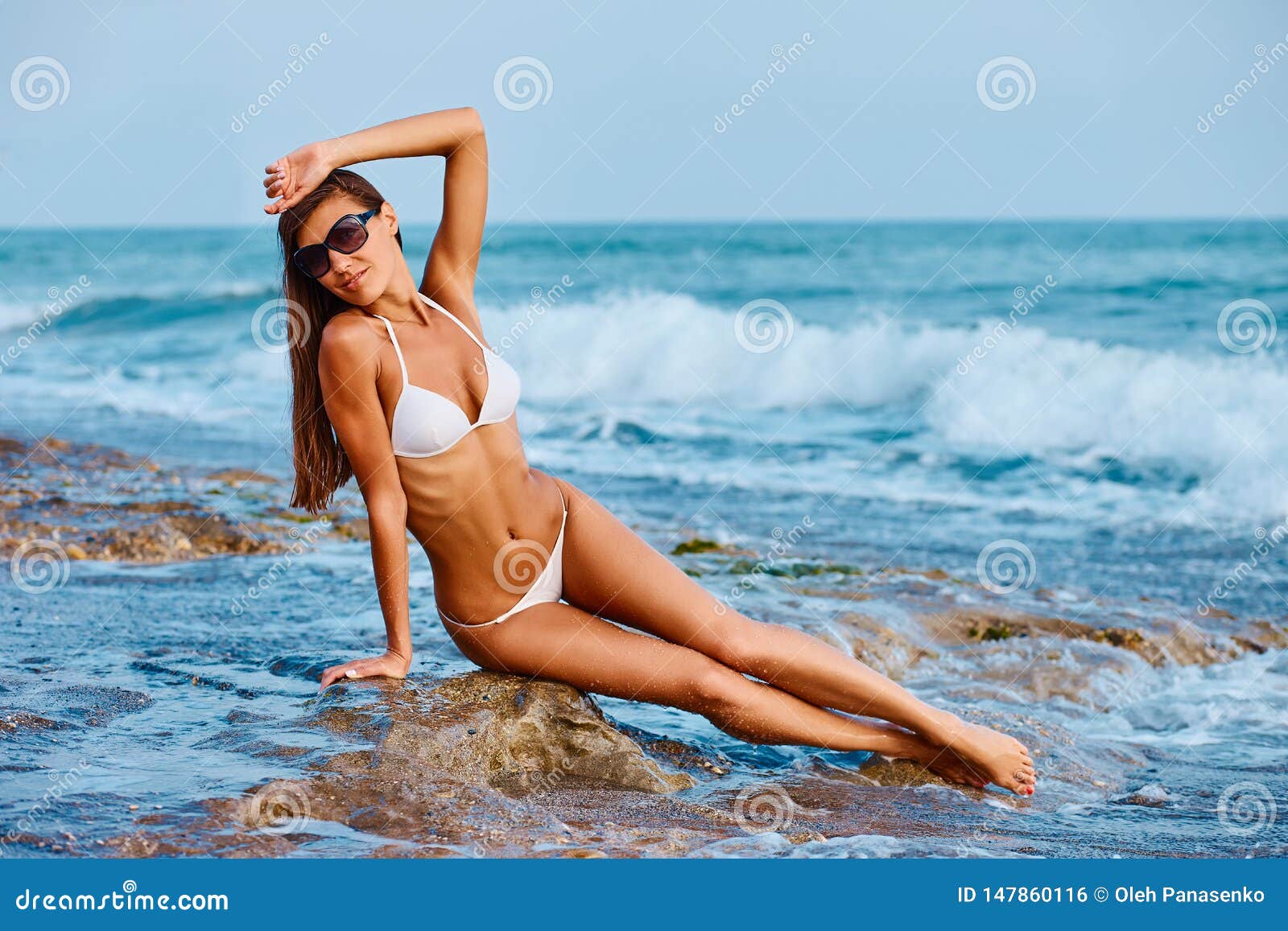 Retrato De La Mujer Bronceada Hermosa Atractiva Que Presenta En Bikini