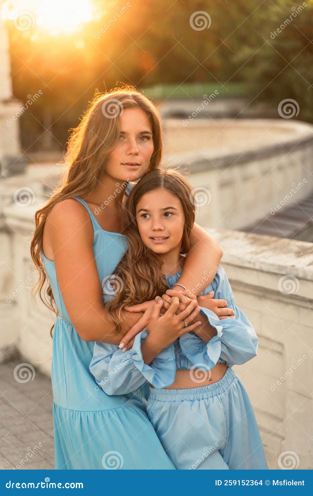 Retrato De Madre E Hija Con Vestidos Azules Con El Pelo Largo Que Fluye Contra El Fondo De La