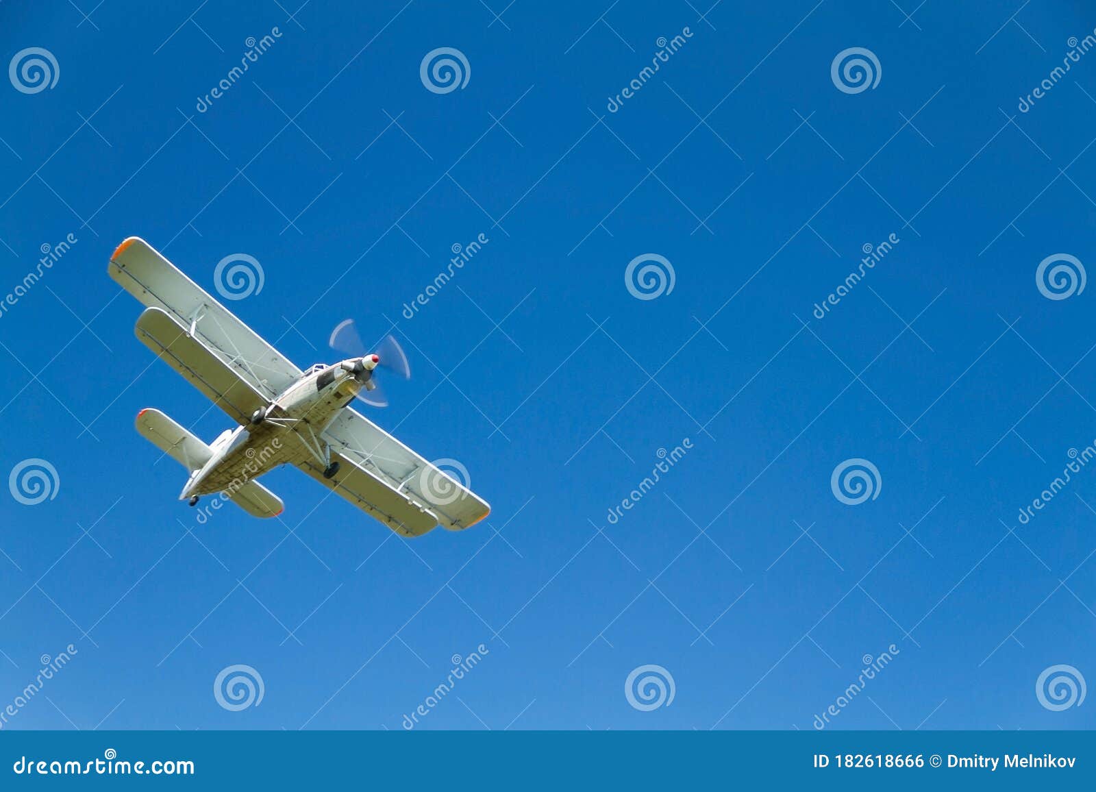 Retro Airplain - Biplane Flying the Air Against a Blue Sky, with a Fast ...
