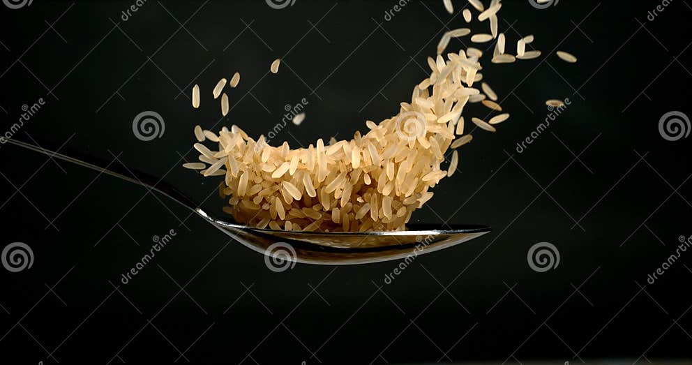 Rice Falling in a Spoon Against Black Background Stock Image - Image of ...