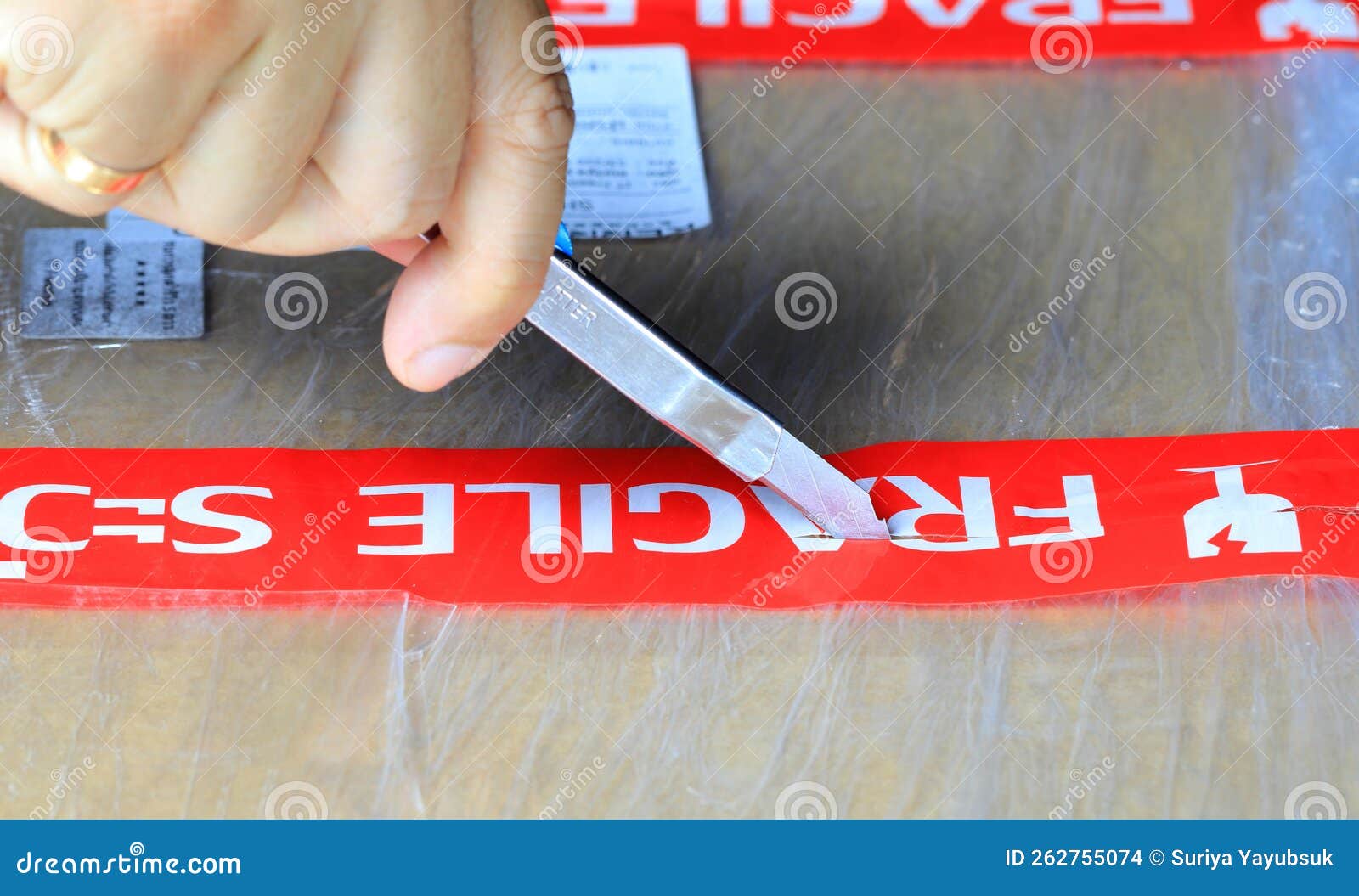 The Right Hand Opening a Box with Fragile Label Using a Small Cutter ...